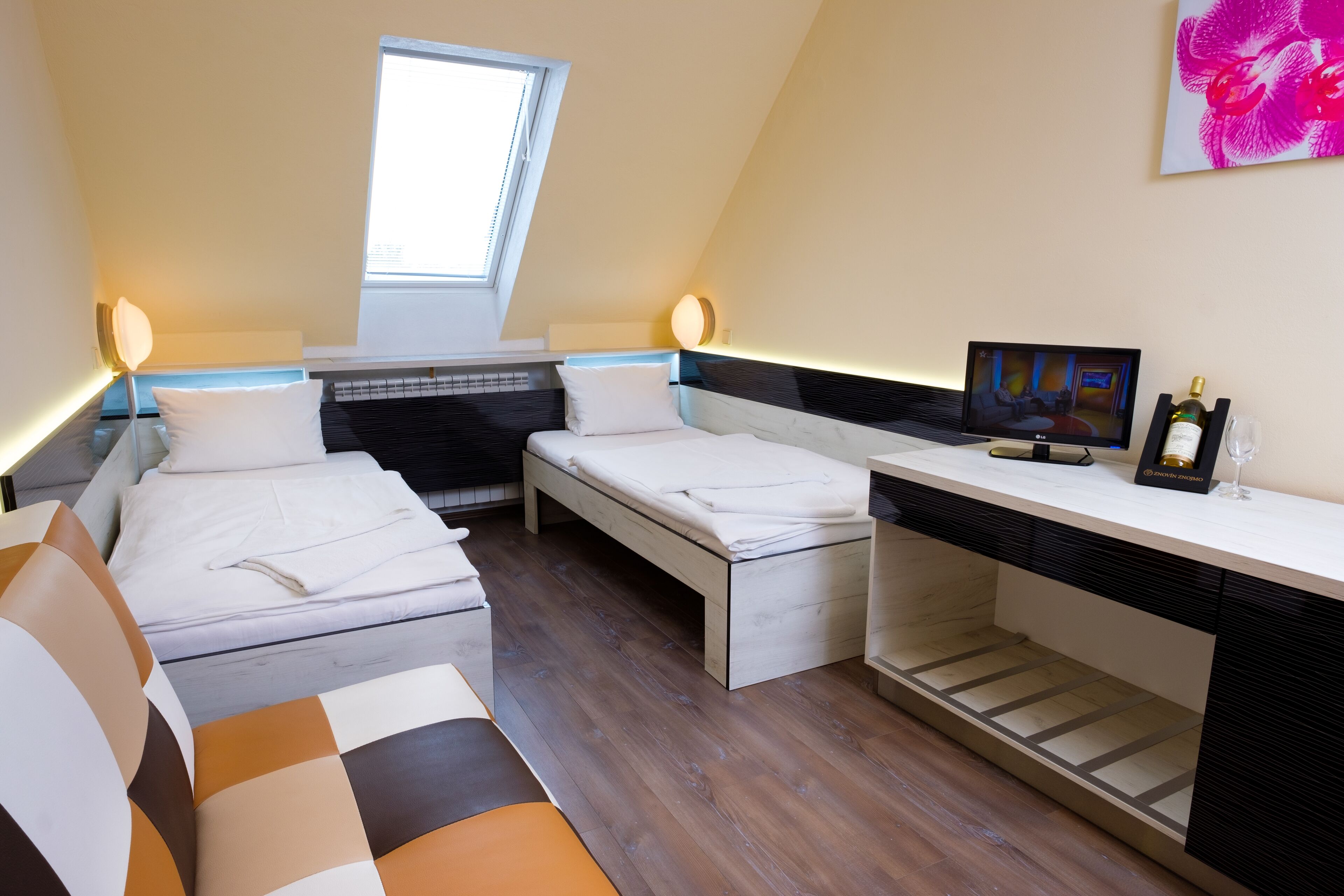 Quarto de hotel moderno com cama beliche, escrivaninha e uma janela grande.