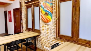 Quarto com parede de tijolos, portas de madeira e uma pintura abstrata colorida.