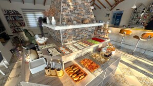 Um buffet de café da manhã com diversos alimentos e utensílios.