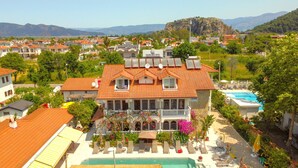 Um edifício grande com piscina, várias varandas e vista para a paisagem ao redor.