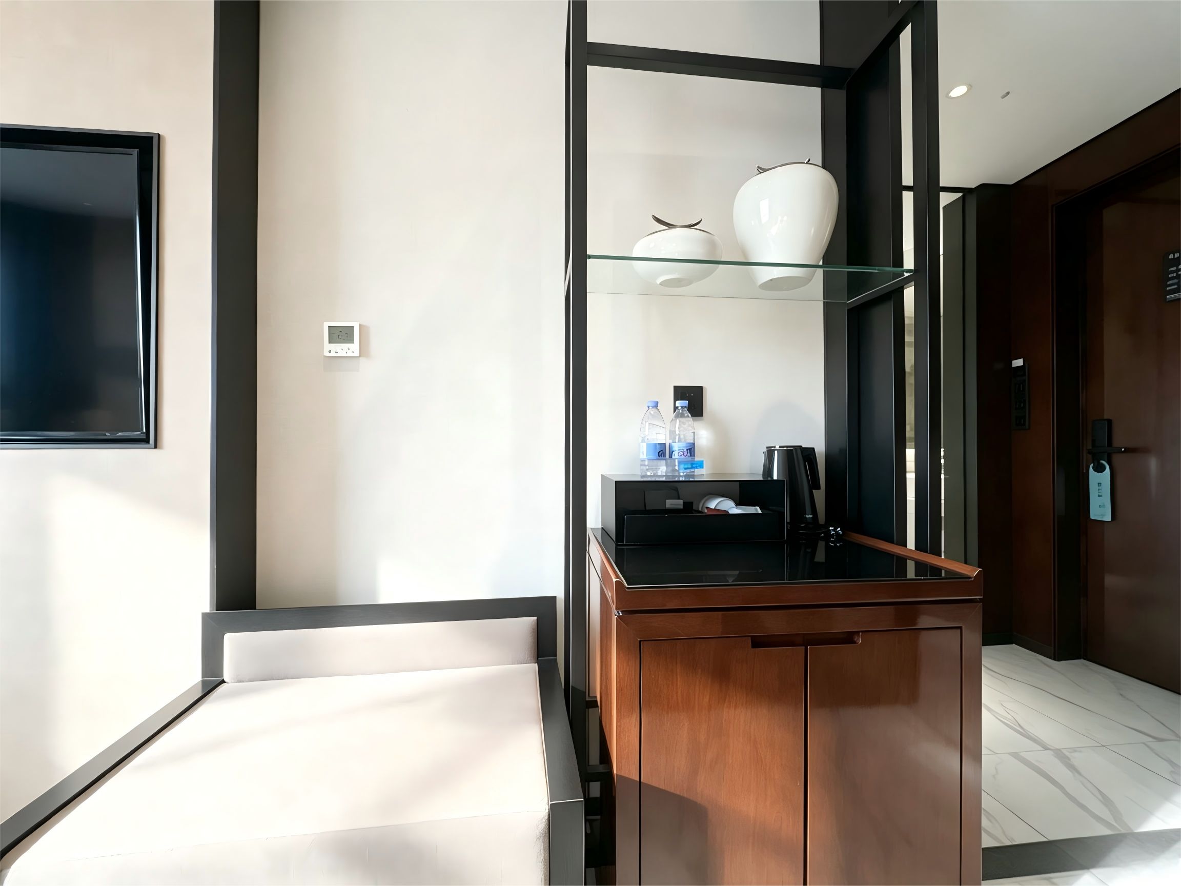 Uma casa de banho moderna com prateleira de vidro, bancada preta e espelho.