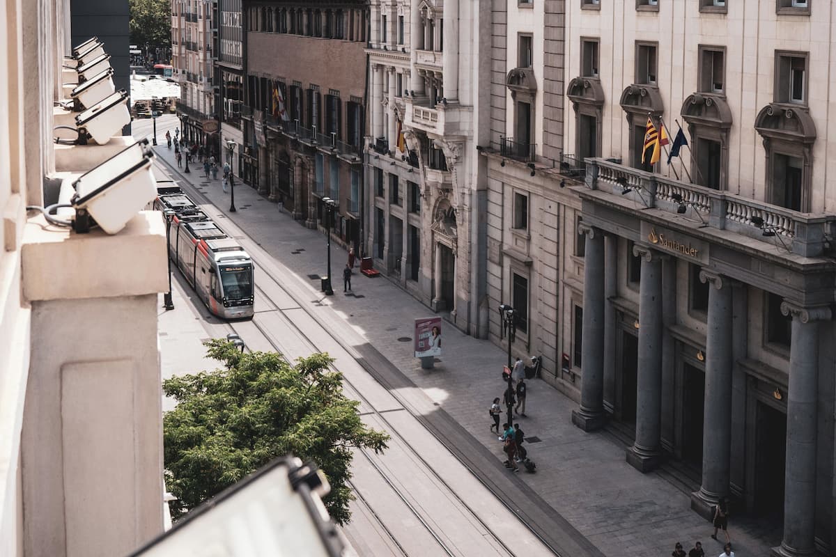 Vista da rua com bonde, edifícios históricos e pedestres.