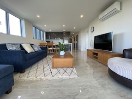 Apartamento Deluxe, 2 quartos, varanda, vista para o rio | Sala de estar | Smart TV de 55 polegadas com canais digitais, televisor