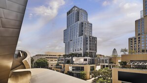 Um edifício moderno de muitos andares com um design angular distinto, cercado por outros edifícios contemporâneos.