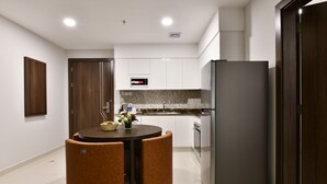 Cozinha moderna com área de refeições, eletrodomésticos de aço inoxidável e painel de azulejos.