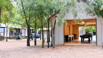 Um edifício com área externa coberta, mesa de bilhar e ventilador de teto.