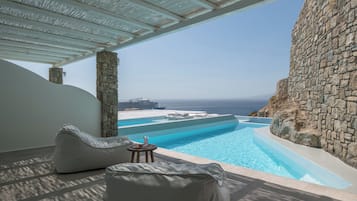 Piscina infinita com vista clara do mar e um cruzeiro ao longe.