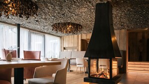 Um interior moderno com lareira, móveis de madeira e um design de teto singular.