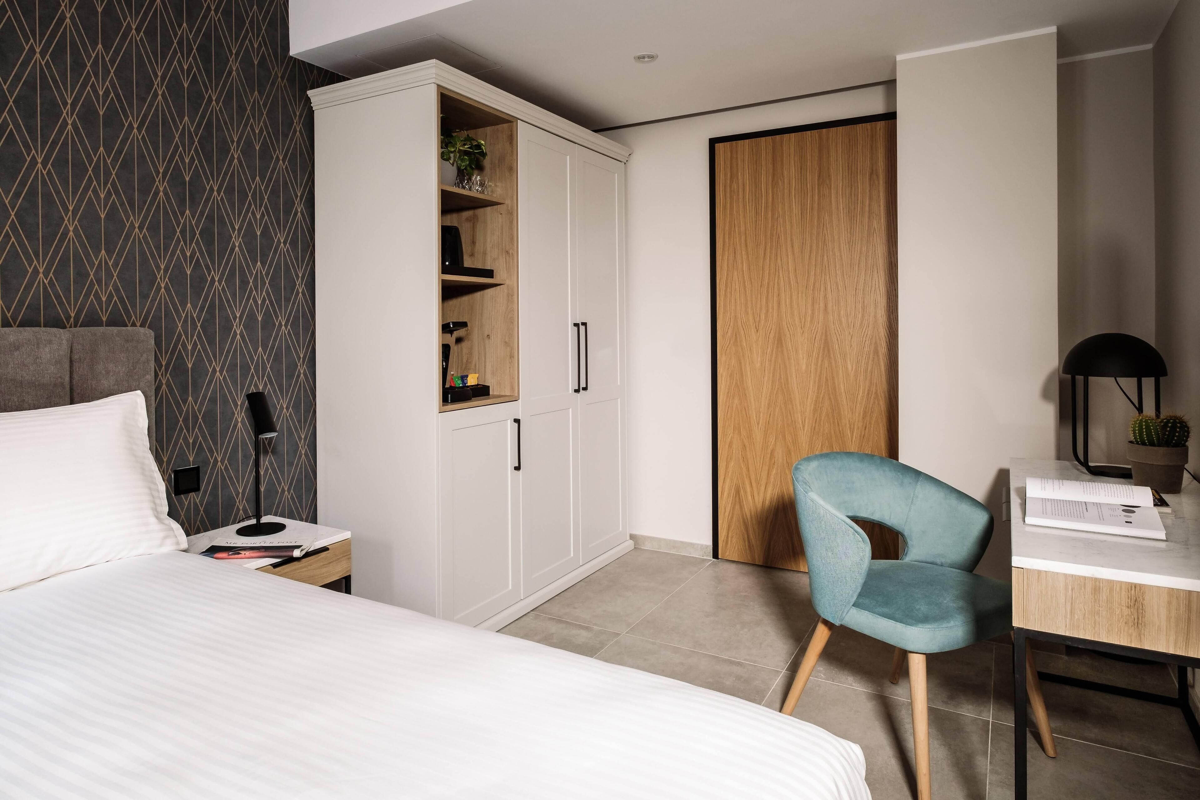 Quarto moderno com uma cama, um guarda-roupa, uma escrivaninha e uma cadeira.
