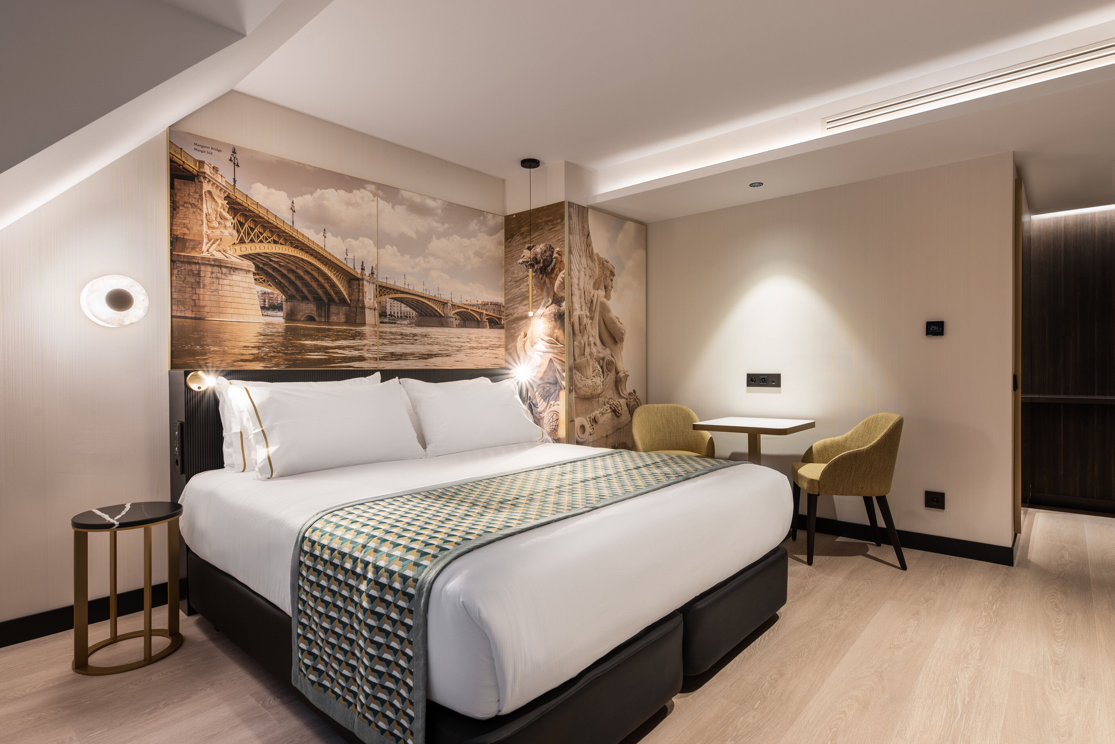 Quarto de hotel moderno com uma cama grande, uma mesa e uma cadeira.