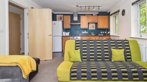 Um espaço compacto com cozinha compacta, sofá e mesa de jantar.
