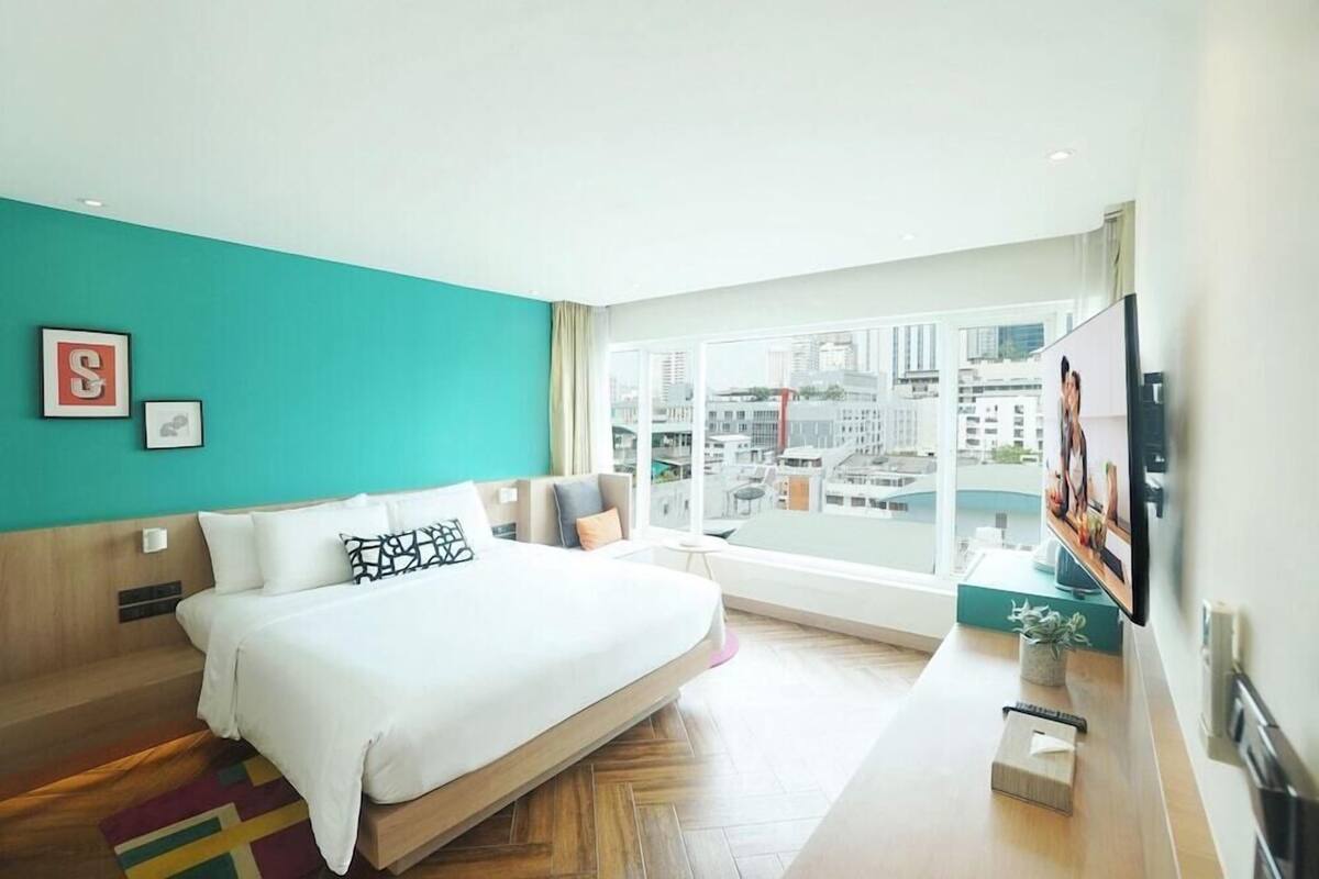 Quarto de hotel com uma cama, vista da cidade, televisão e janela.