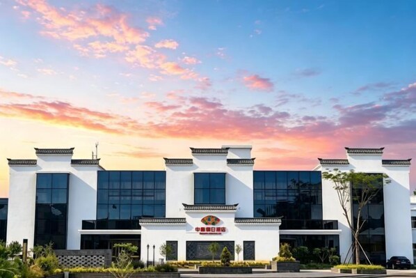 Um edifício moderno com estilo arquitetônico tradicional, apresentando grandes janelas e um logotipo destacado.