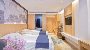 Quarto de hotel com duas camas, uma escrivaninha, uma televisão e uma grande obra de arte na parede.