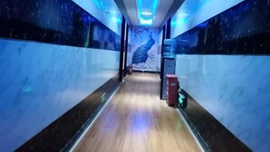 Um corredor com piso de madeira, iluminação azul e um mural na parede.
