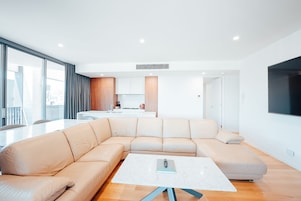 Apartamento premium (Executive Retreat with Water Views) | Área de estar | Smart TV 85 polegadas com canais digitais, TV, Netflix