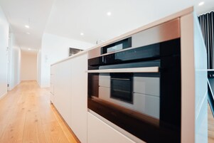 Apartamento premium (Executive Retreat with Water Views) | Cozinha privada | Geladeira grande, micro-ondas, fogão, cooktop
