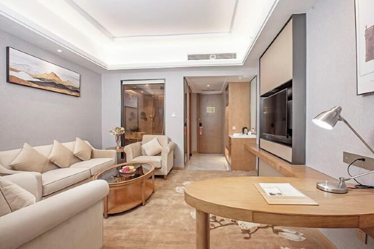 Uma sala de estar moderna com sofá, mesa de centro e televisão.