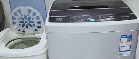 Máquina de lavar roupa branca com tampa azul e painel de controle.