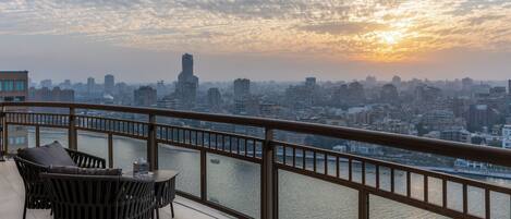 Uma varanda com vista para o horizonte urbano e um rio.