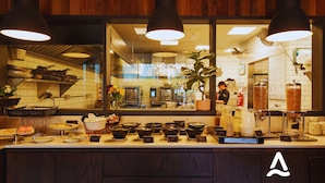 Um balcão de buffet com diversos alimentos e uma estação de café.