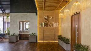 Interior moderno com uma receção de madeira, um espelho e um sinal fixado na parede.