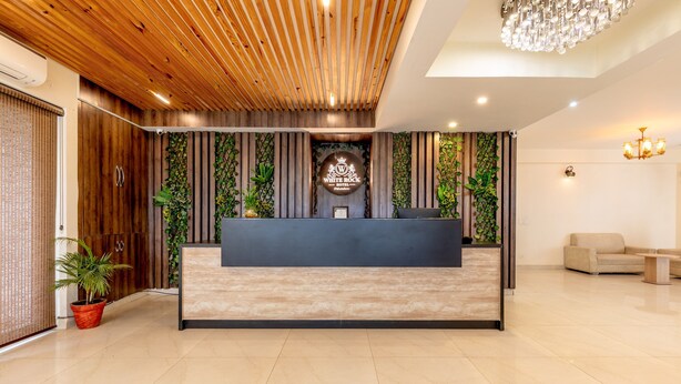 Uma área de recepção com teto de madeira, balcão de atendimento e plantas em vasos.
