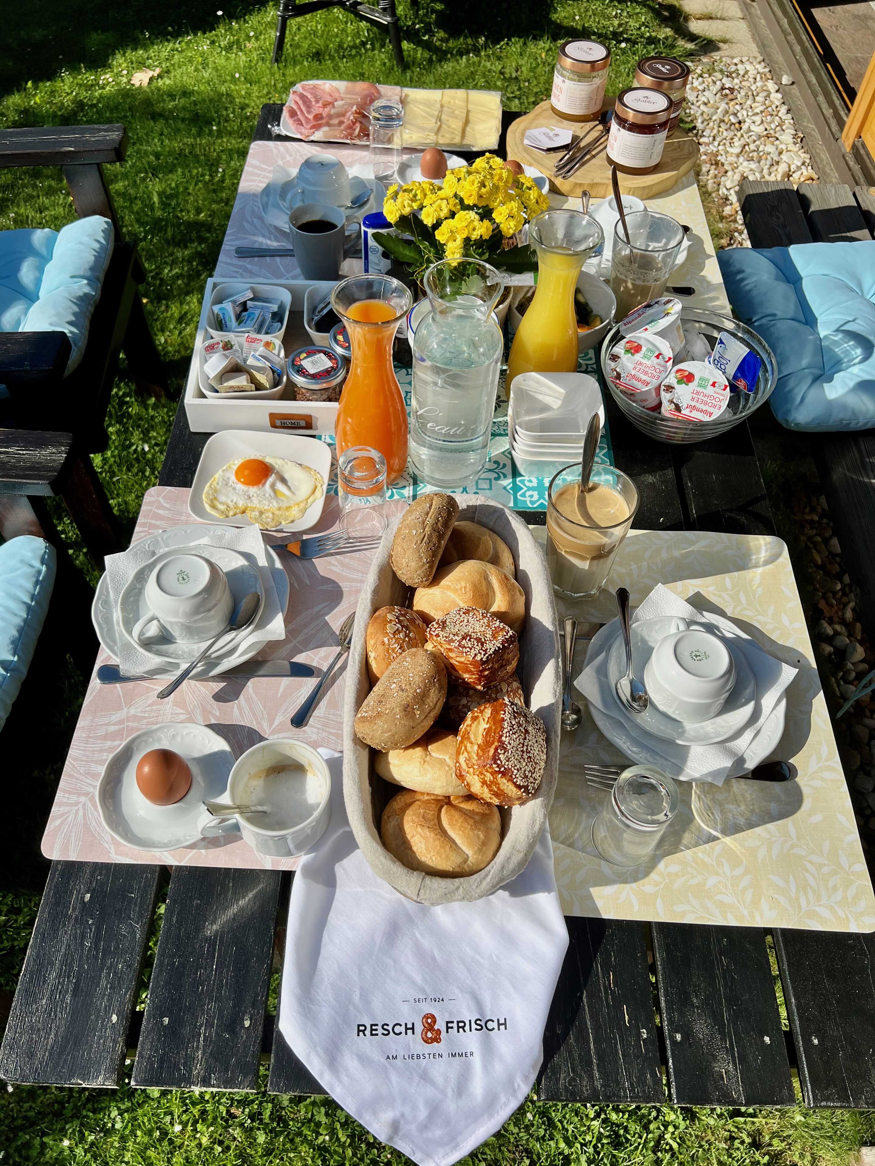 Uma mesa posta para o café da manhã, com pão, ovos e bebidas.