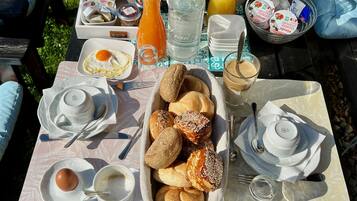 Uma mesa posta para o café da manhã, com pão, ovos e bebidas.