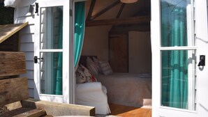 Um quarto aconchegante com cama, cortinas e teto de madeira.