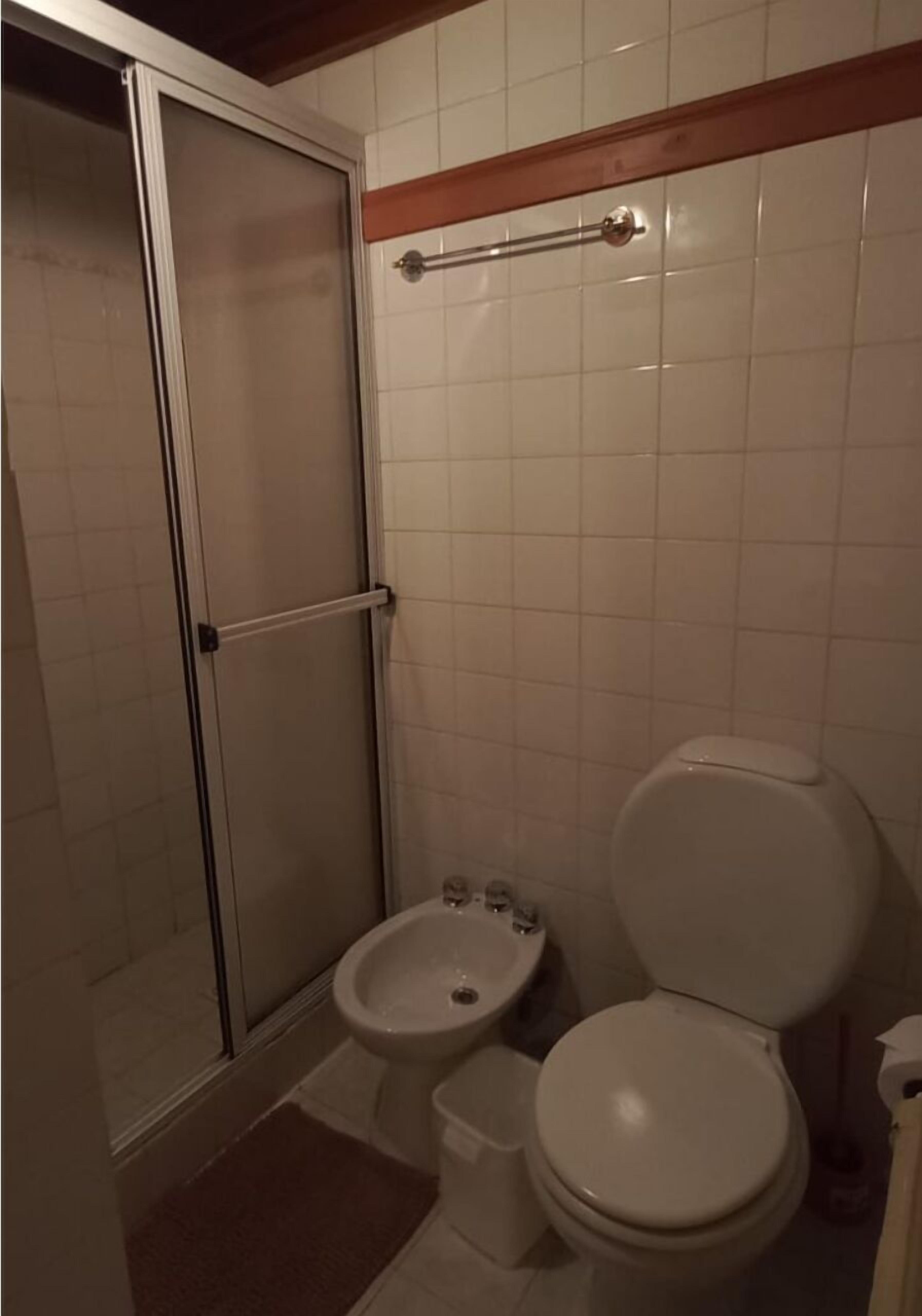 Casa de banho com chuveiro, sanita e bidé.