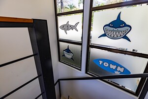 Escada com painéis de vidro com ilustrações de tubarões e a palavra "TOWN".