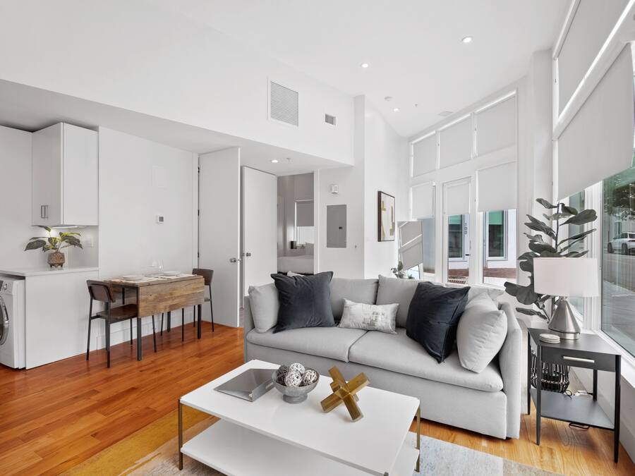 Uma sala de estar moderna com sofá, mesa de centro e área de jantar.