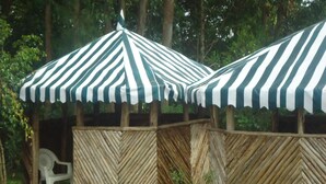 Duas tendas listradas com cerca de madeira em padrão herringbone.