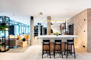Decoração moderna com área de bar central, assentos e uma grande janela que oferece luz natural.