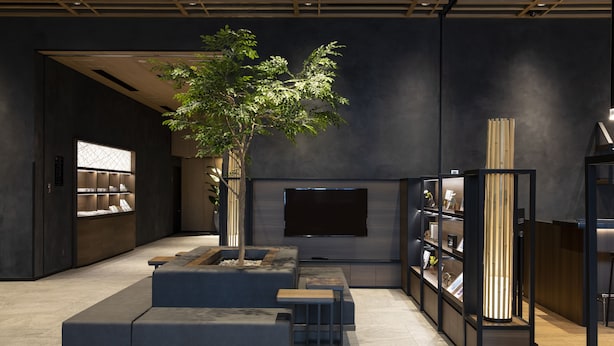 Um interior moderno com sofá modular, televisão de tela plana e uma seleção de livros e objetos decorativos.
