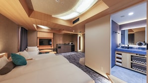 Quarto de hotel com cama grande, escrivaninha, cozinha compacta e banheiro com espelho.