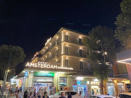 Um hotel com vários andares e uma placa visível que diz 'AMSTERDAM SUITE HOTEL & SPA'.