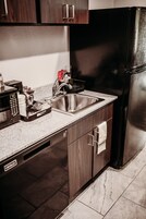 Cozinha com pia de aço inoxidável, micro-ondas e lava-louças.