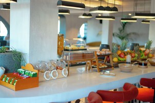 Um buffet de café da manhã com diversos alimentos e uma seleção de frutas.