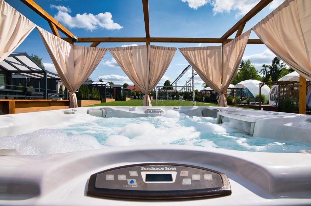 Uma área de hidromassagem com um painel de controle identificado como "Sundance Spas" e "Clear Bay".