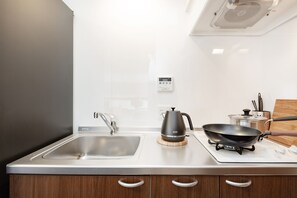 Um frigorífico/congelador grande, um micro-ondas, uma placa de cozinha 