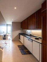 Cozinha moderna com armários de madeira, bancada preta e painel de azulejos.