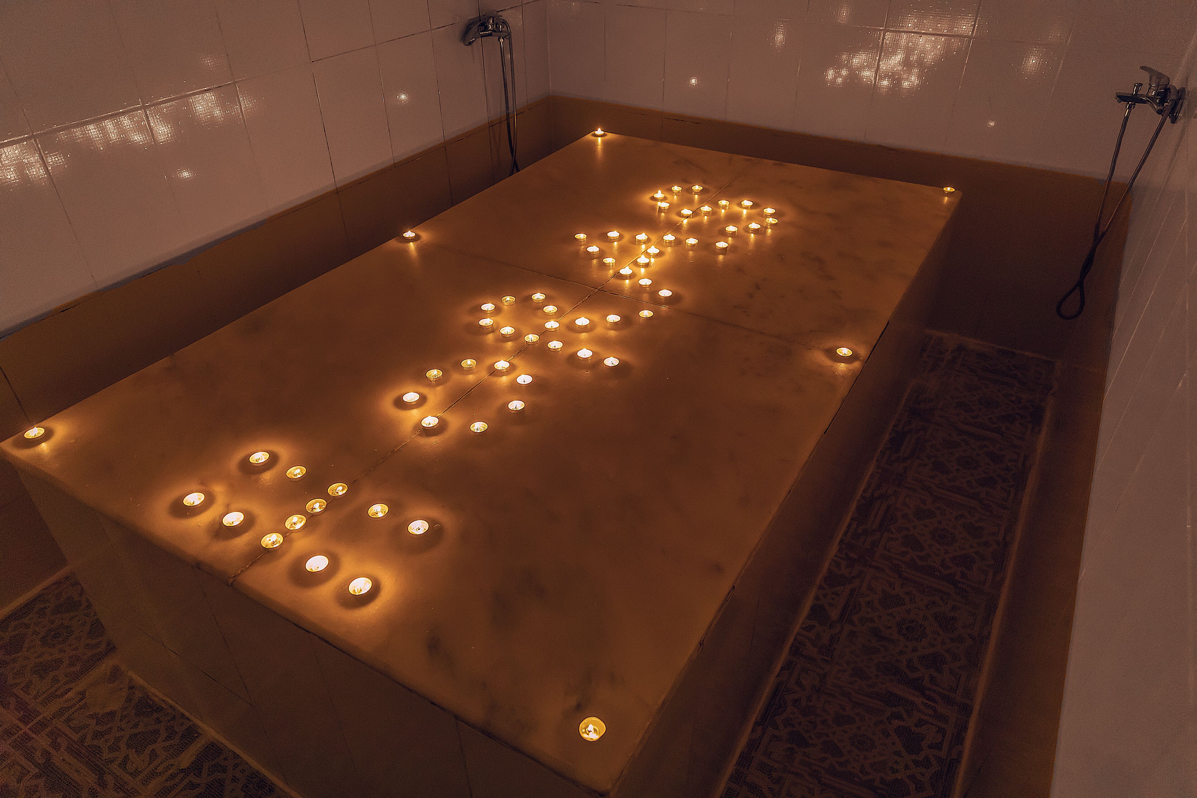 Uma banheira com velas dispostas em formato de coração.