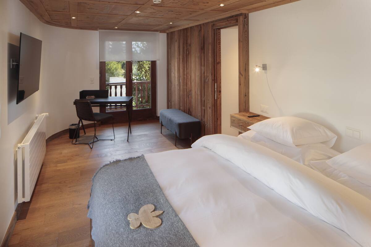 Quarto com cama, escrivaninha e cadeira.