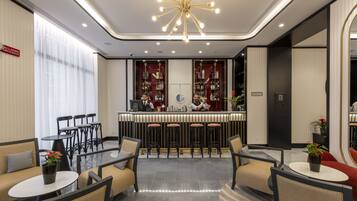 Uma área de bar moderna, com balcão, banquetas e um bartender.