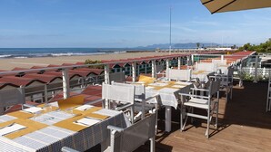 Restaurante à beira-mar com área externa e vista para a praia.