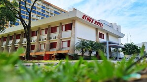 Um hotel chamado ATHUS HOTEL, com um design arquitetônico moderno, com vários andares e uma entrada imponente.
