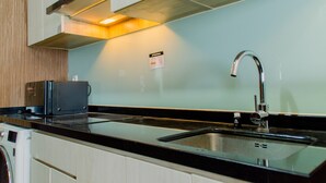 Uma cozinha moderna com uma pia de aço inoxidável, micro-ondas e forno embutido.