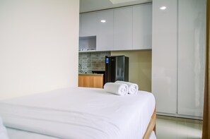 Quarto de hotel com cama, cozinha e banheiro.